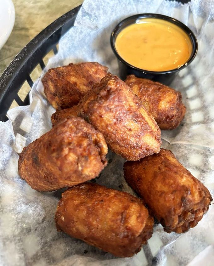 Golden-brown crab tater tots that make you question why regular tots even exist. The accompanying sauce deserves its own fan club.