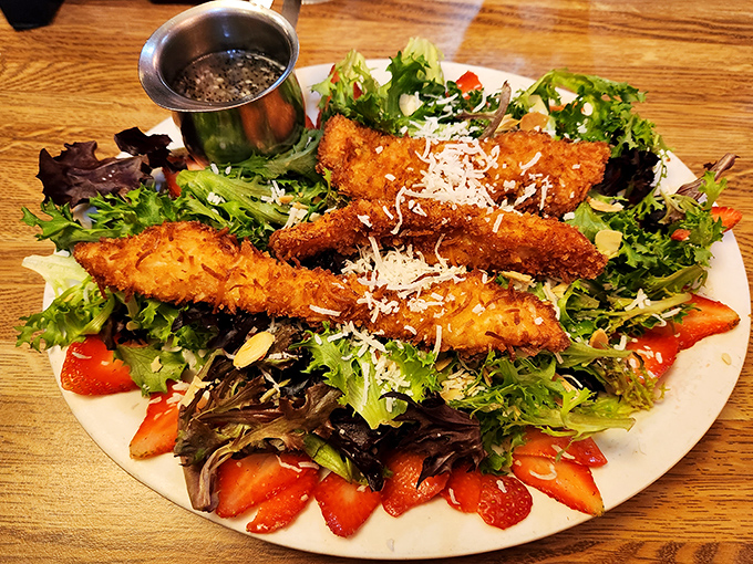 Crispy chicken strips stand at attention atop a bed of fresh greens, proving that salads don't have to be punishment for dietary sins.