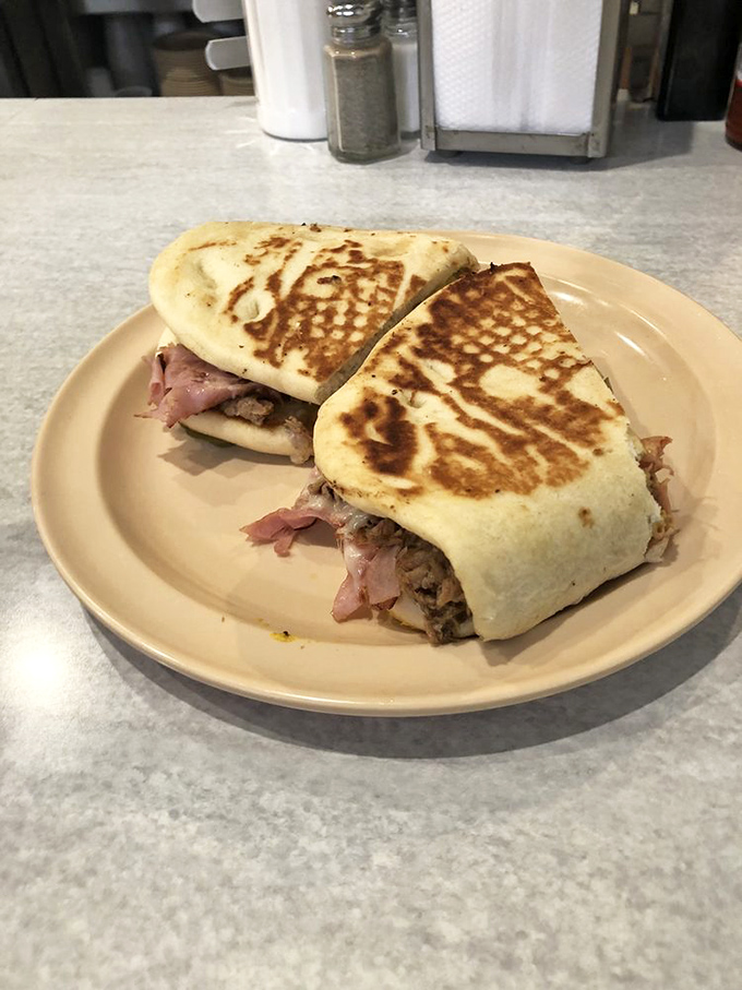 This pressed sandwich isn't just food; it's architectural genius. Layers of flavor compressed into handheld perfection that makes lunch meaningful again.
