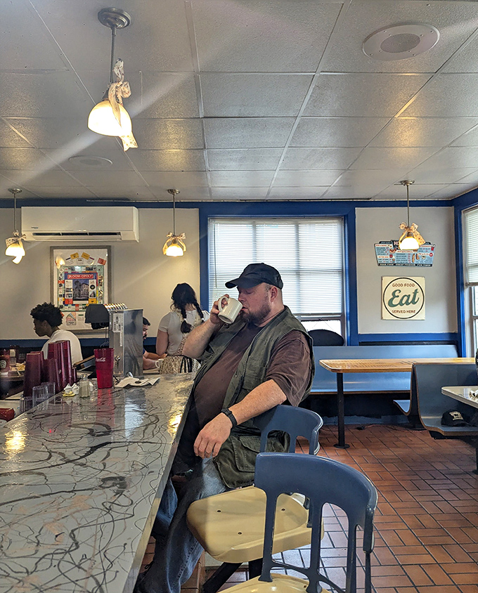 The universal gesture of diner contentment: that first sip of coffee while contemplating the feast that's about to arrive.