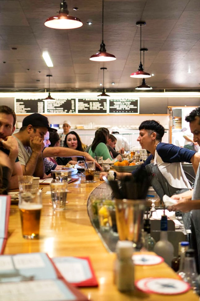 The communal counter experience&mdash;where strangers become friends united by the universal language of "pass the hot sauce, please."