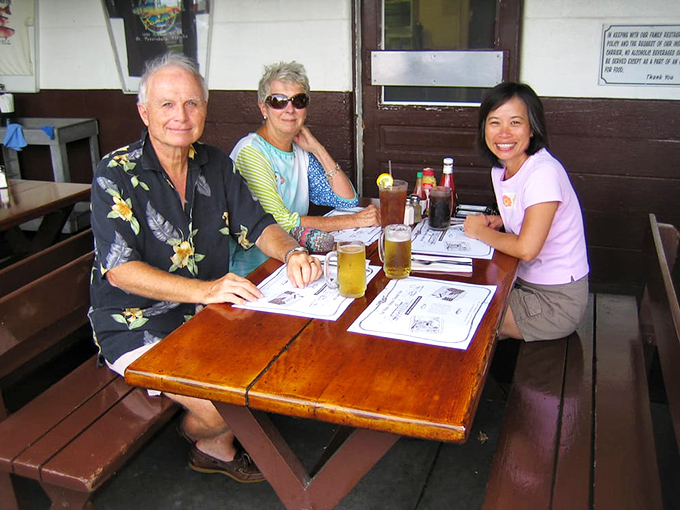 Happy diners enjoying the simple pleasure of great food and cold drinks. That "I can't believe we found this place" smile is universal.