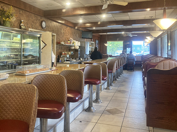 The counter seats offer front-row views to the breakfast show. Early birds catch both the worm and the freshest coffee at these coveted spots.