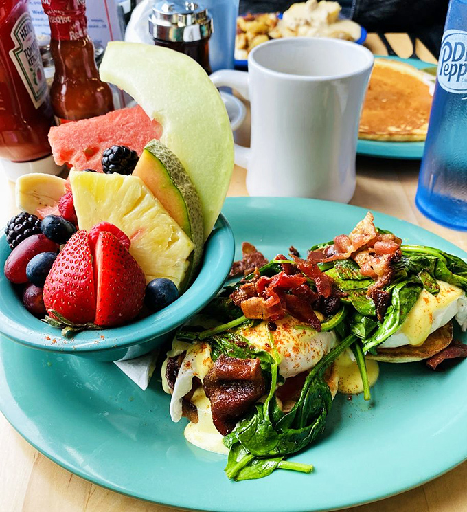 Breakfast that understands balance&mdash;fresh fruit for your conscience, eggs Benedict for your soul. That spinach technically makes this health food, right?
