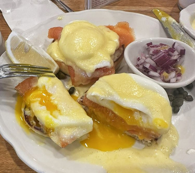 Eggs Benedict with hollandaise cascading like a yellow waterfall&mdash;breakfast's answer to formal wear, with a side of chopped onions.