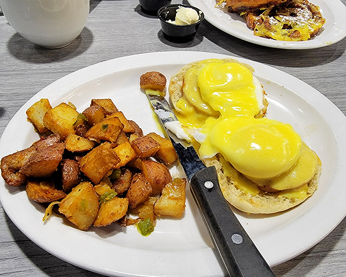 Eggs Benedict arrives with hollandaise that flows like liquid gold over perfectly poached eggs and toasted muffins.