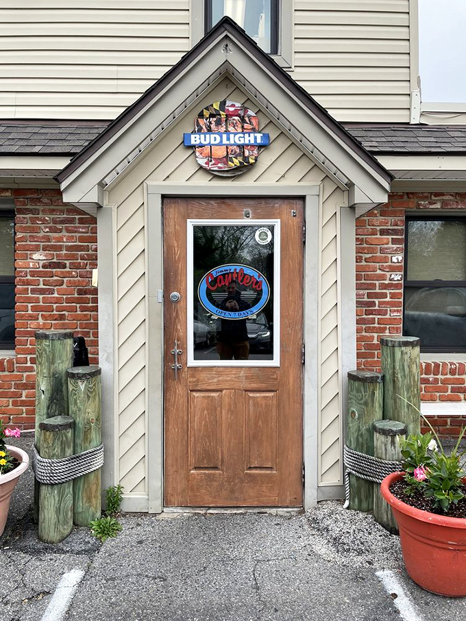 This welcoming entrance promises authentic Maryland flavors just beyond that weathered wooden door and brick facade.