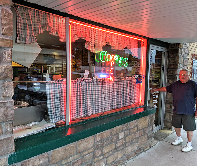 The neon glow of Cooky's sign in the window serves as a beacon for hungry travelers, promising comfort and satisfaction just steps away.