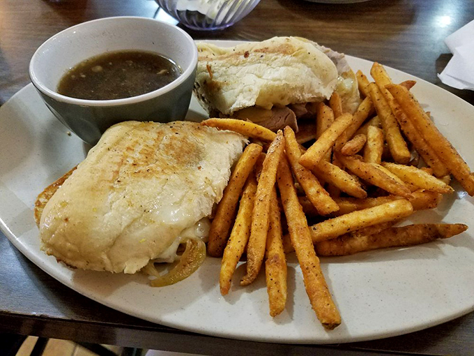 A French dip sandwich with perfectly seasoned fries and savory au jus for dipping—proof that sometimes the messiest foods are the most satisfying.