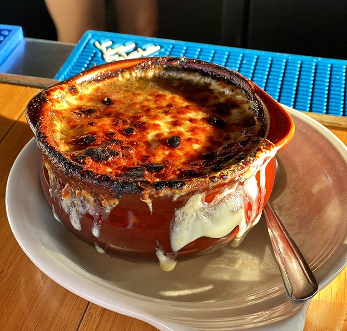 French onion soup arrives bubbling hot, providing comfort food perfection on cooler lakeside evenings.