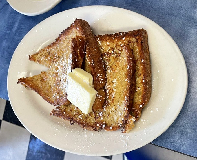 French toast that's achieved that mythical balance&mdash;crispy edges, custardy center, and a snowfall of powdered sugar that makes every bite a celebration.