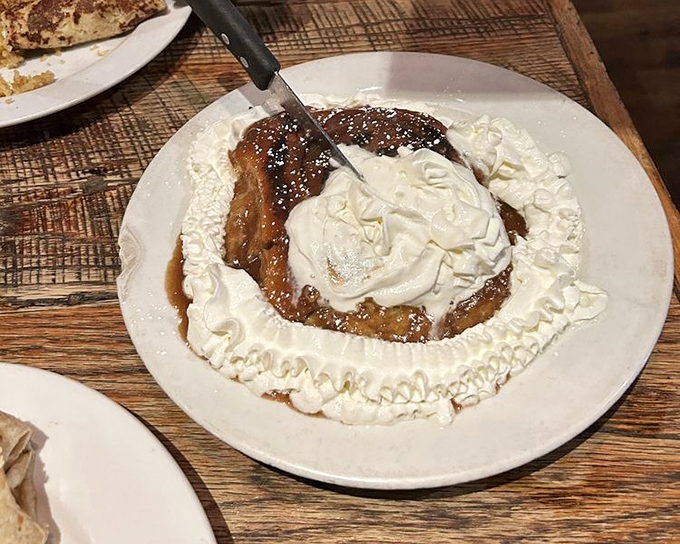 Not just a cinnamon roll but a throne of sweetness, crowned with whipped cream and ready for its royal appointment with your taste buds.