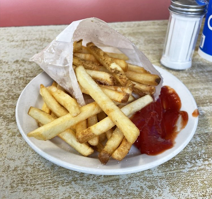 Fries that strike the perfect balance between crispy exterior and fluffy interior. The paper bag is both nostalgic and practical for catching every last crumb.