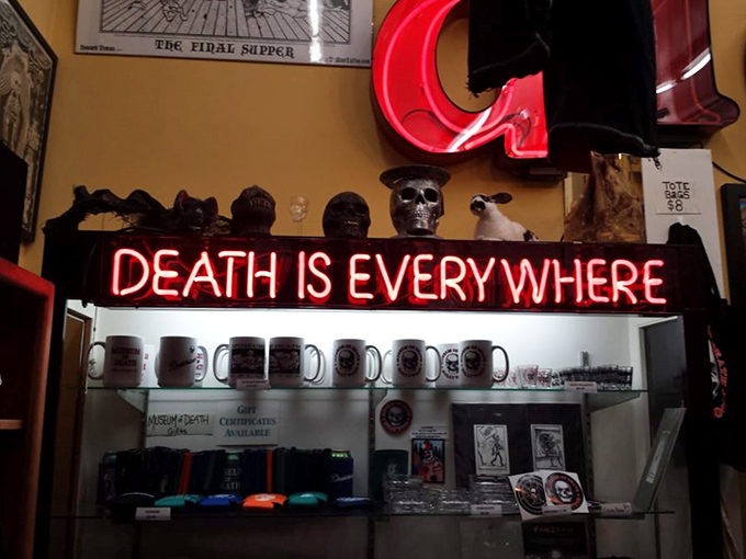 The gift shop's "Death is Everywhere" neon sign perfectly captures the museum's straightforward approach to life's ultimate certainty.;