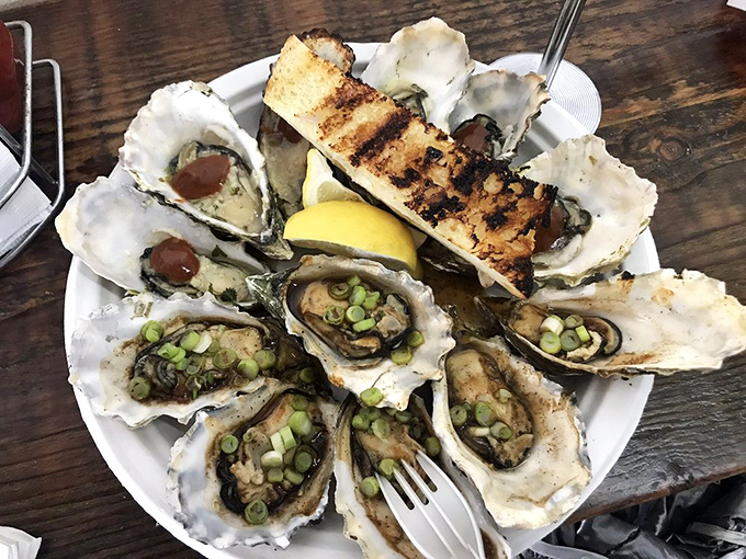 Briny, buttery grilled oysters topped with scallions and mystery sauce. Each shell holds a tiny ocean of flavor waiting to be discovered.