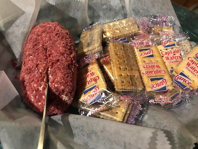 The homemade cheese ball arrives with crackers standing by like eager soldiers, ready to transport this creamy, savory delight from plate to palate.
