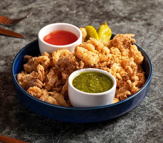 Crispy calamari that shatters with each bite, served with dipping sauces that make you wonder why you'd ever share this plate.