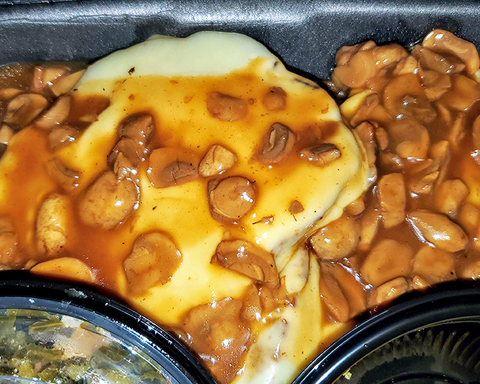 Mashed potatoes swimming in gravy that's practically liquid gold, making every bite taste like comfort and childhood and victory all at once.