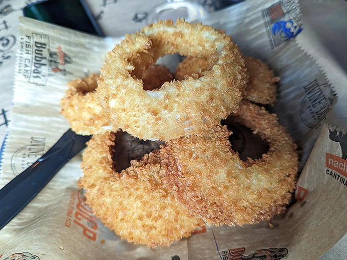 Golden-fried onion rings that shatter with each bite. These aren't just sides&mdash;they're crispy halos of happiness worth fighting over.