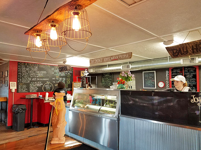 The counter where BBQ dreams become reality. Industrial pendant lights and a sign reminding staff that kindness matters as much as the food.