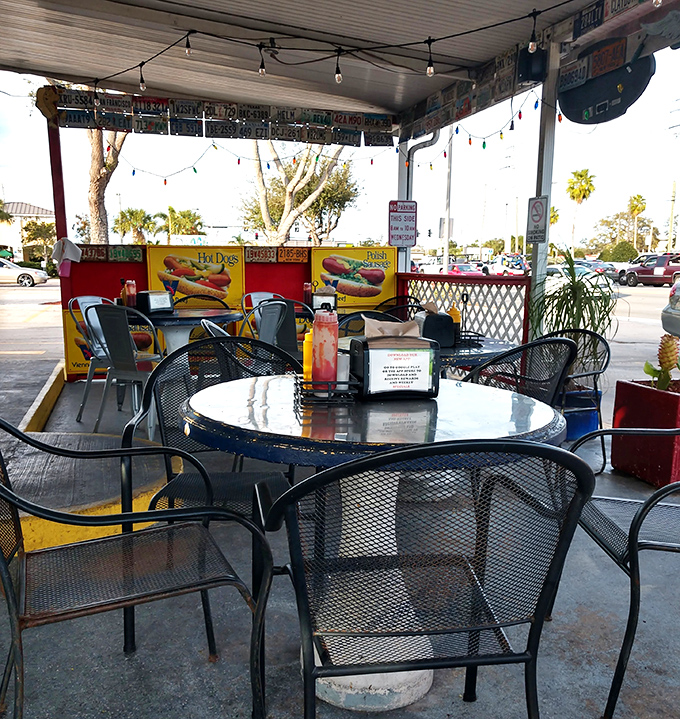 Colorful string lights and bright metal chairs create an outdoor oasis where hot dogs taste even better under the Florida sky.