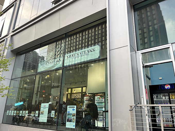 The "SHAY'S STEAKS" sign serves as a beacon for sandwich seekers navigating the concrete canyons of downtown Philadelphia.