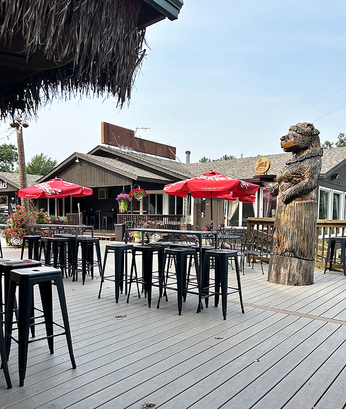 Summer dining al fresco with that carved bear standing guard – lakeside meals taste better with a side of fresh air.