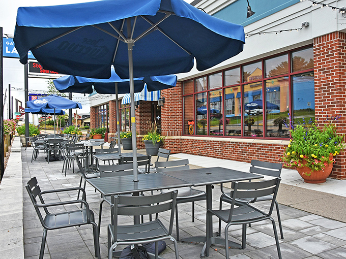 The outdoor patio offers fresh air dining under Wisconsin skies, with those signature blue umbrellas providing just enough shade.