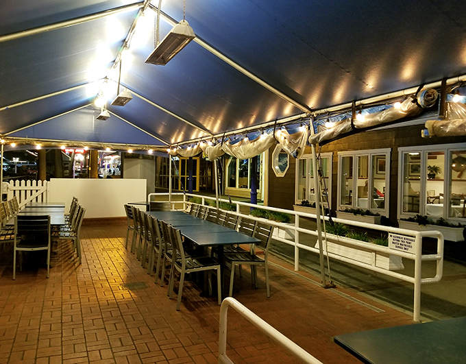 Nighttime transforms the outdoor dining area into a twinkling seaside escape, where conversations flow as freely as the wine.