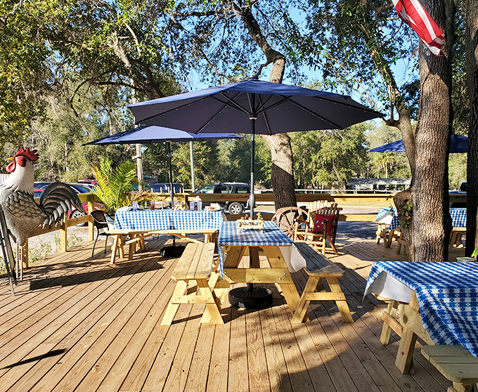 Blue-checkered tablecloths under Florida sunshine create the perfect outdoor dining spot. That rooster statue isn't just decoration&mdash;he's the unofficial greeter.