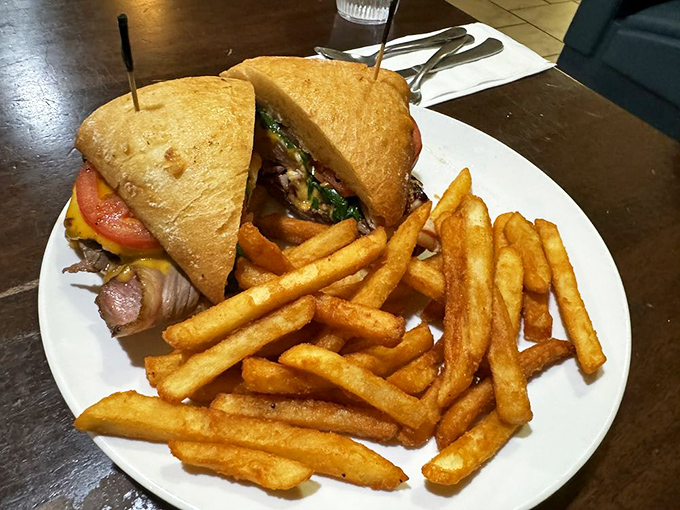 A proper diner sandwich stands tall and proud, secured with toothpicks like tiny structural supports for this architectural marvel of lunch.