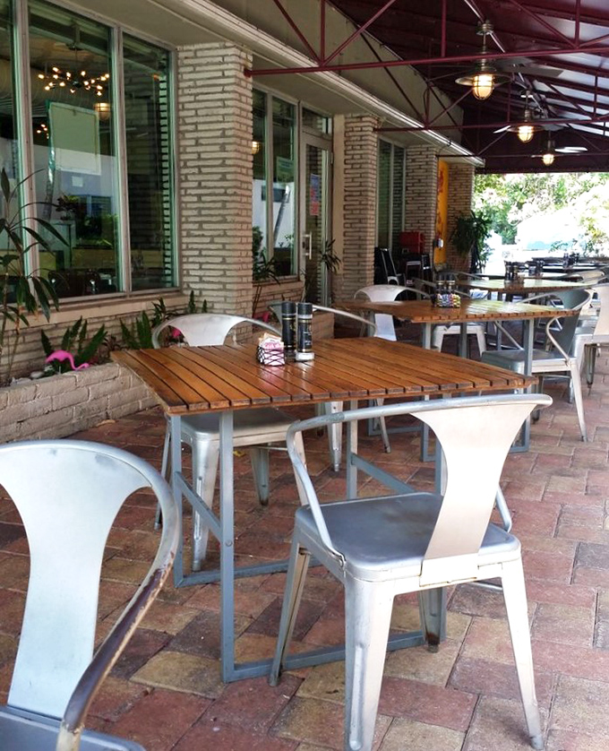 The patio seating offers a perfect Florida alfresco dining experience&mdash;where brick, wood, and metal create an industrial-chic vibe under the gentle protection of palm fronds. 