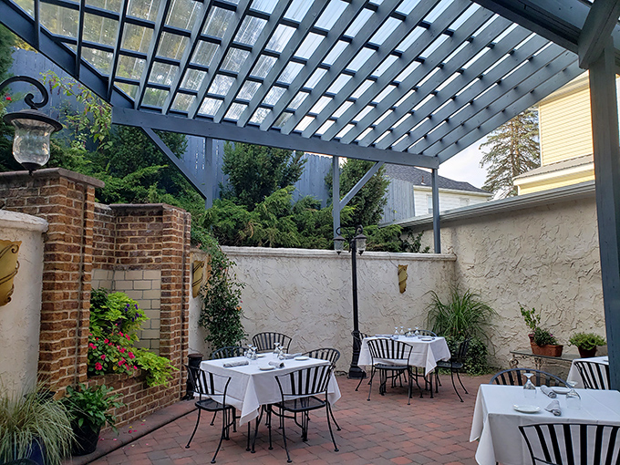 Dining al fresco under a pergola surrounded by brick and greenery&mdash;like eating in a secret garden where the secret is exceptional food.