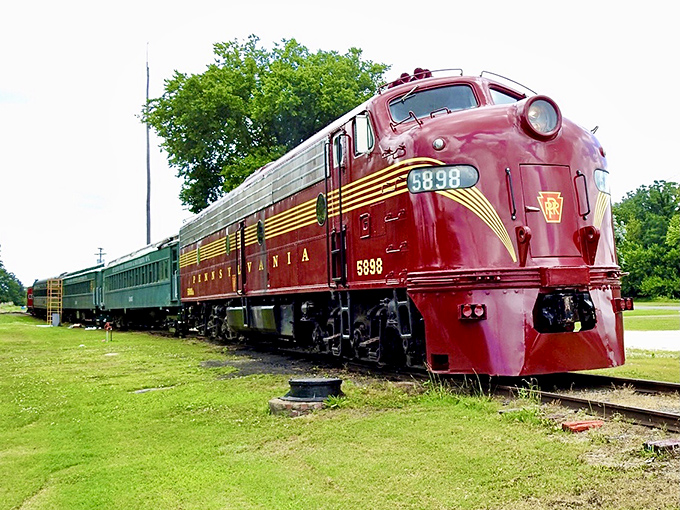 The Pennsylvania Railroad's crimson locomotive stands proud, its streamlined design a perfect marriage of power and elegance. Art deco on wheels.