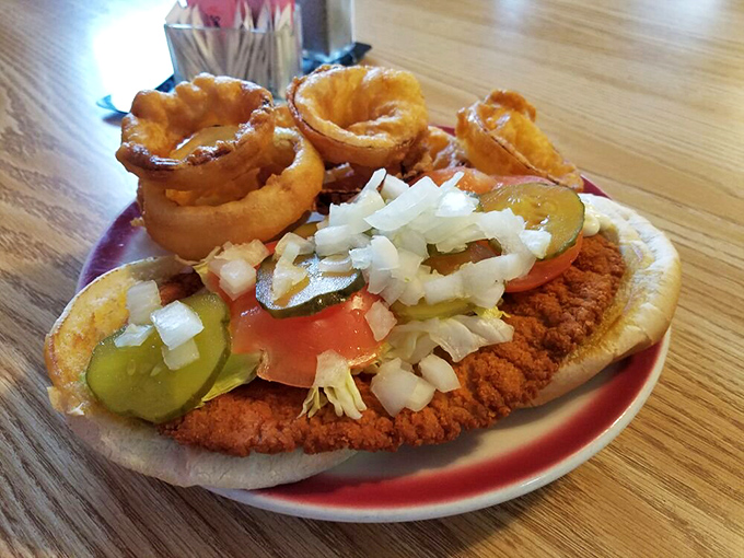 This pork tenderloin sandwich has ambition – it's clearly trying to escape the boundaries of its plate. Those onion rings are the perfect accomplices.