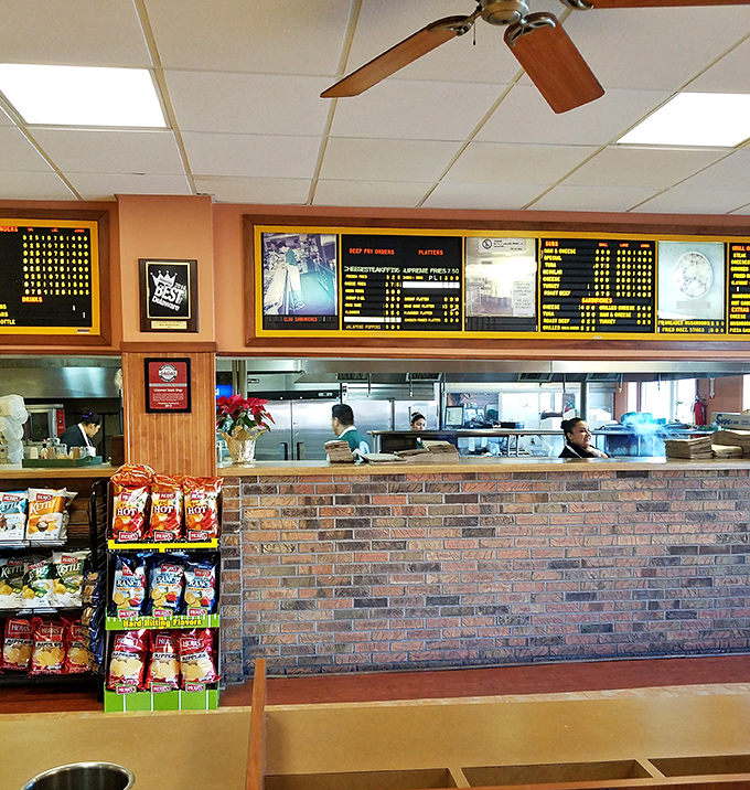 The grill master at work, transforming simple ingredients into legendary sandwiches with practiced hands and perfect timing.