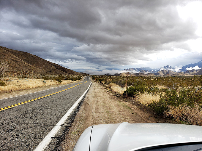 The road stretches toward distant peaks, promising adventure seekers that the journey through Anza-Borrego is just as magnificent as any destination.