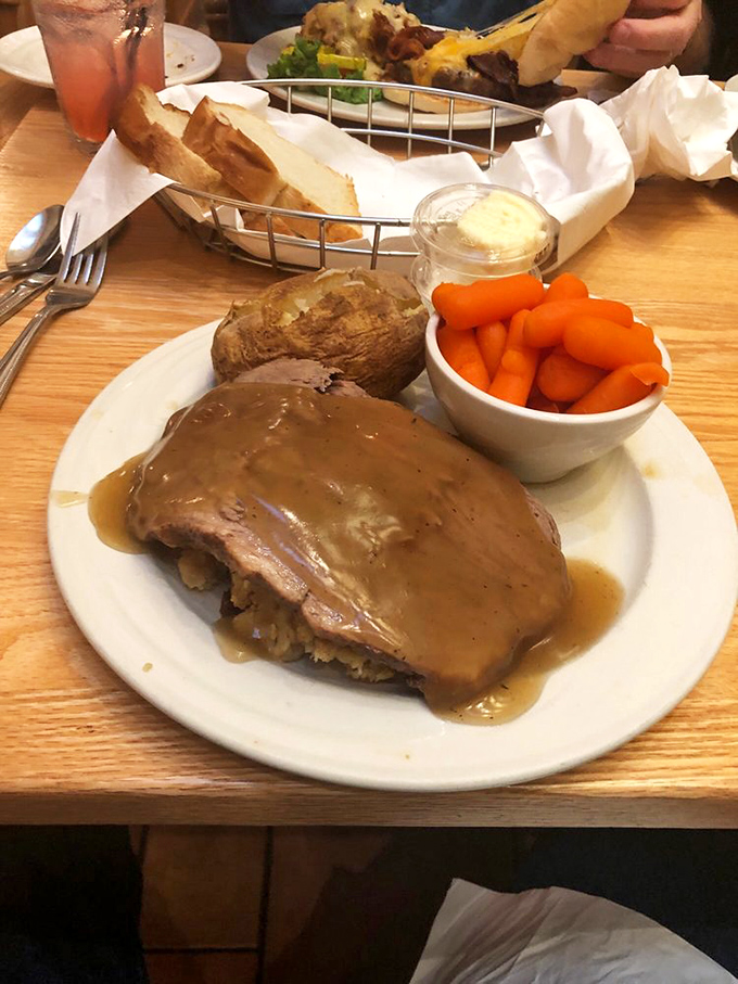 Roast beef so tender it practically surrenders to your fork, accompanied by carrots standing at attention in their little white bowl.
