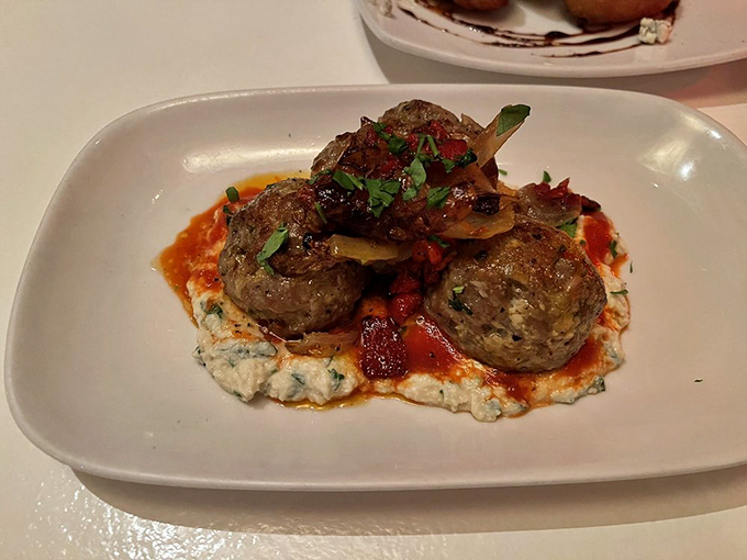 These meatballs aren't just appetizers&mdash;they're little ambassadors of flavor perched atop a creamy sea of what must be someone's grandmother's recipe.