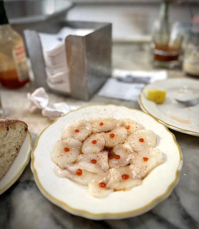 Scallop sashimi dotted with tiny pearls of roe &ndash; delicate, sweet morsels that taste like the ocean's most elegant whisper.