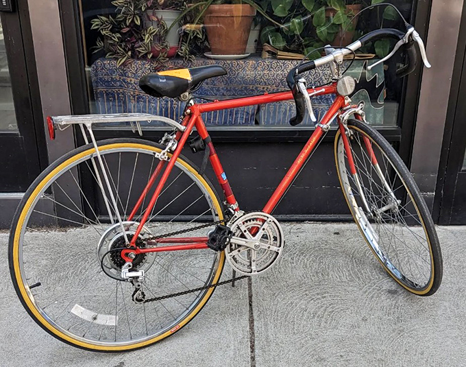 A vintage road bike leaning casually outside, like it's waiting for its hipster owner to finish browsing vinyl records inside.