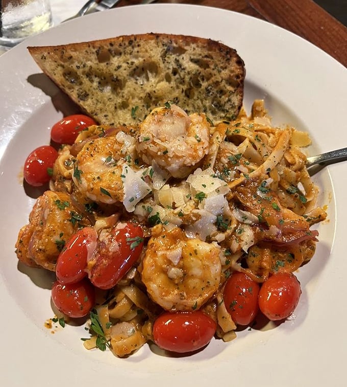 Shrimp pasta that's worth every carb. Those cherry tomatoes burst with sunshine, while the garlic bread stands by, ready for its supporting role.