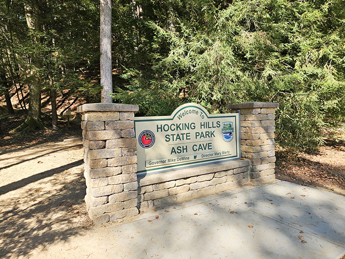 The entrance sign to Ash Cave: where cell service disappears but your connection to nature gets five bars.