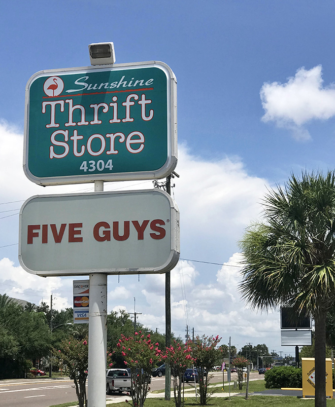 The iconic Sunshine Thrift sign stands tall against Florida's blue sky, conveniently located next to Five Guys for those who work up an appetite while bargain hunting.