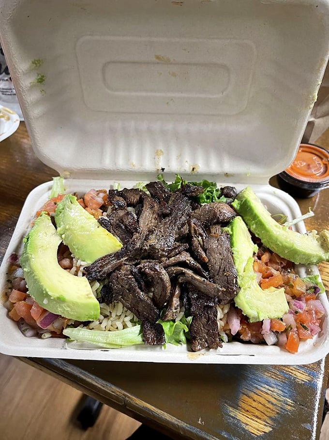 A bowl that's practically a work of art—perfectly sliced avocado crowns seasoned rice, fresh pico, and skirt steak cooked to perfection.