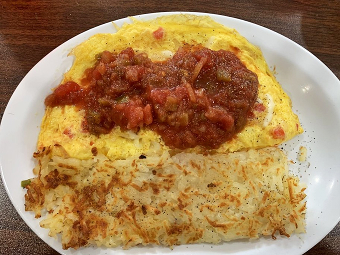 An omelet that's been to Spain and back, bringing home tales of tomatoes and spices. Those hash browns are its perfect traveling companion.