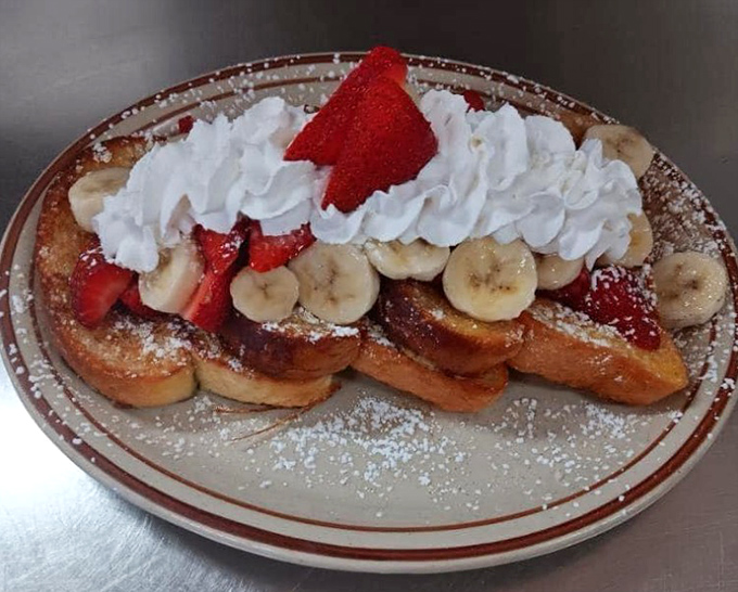French toast that crossed over to the dessert side, topped with fresh strawberries, bananas, and enough whipped cream to make a cloud jealous.