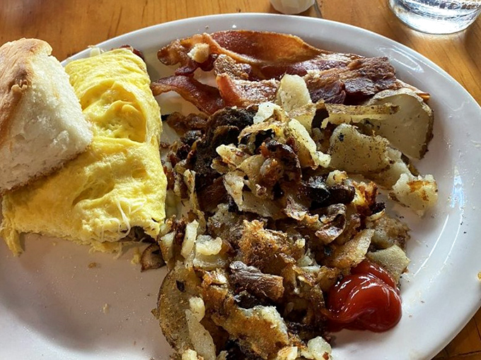 The omelet that launched a thousand return visits, accompanied by crispy potatoes that deserve their own fan club.
