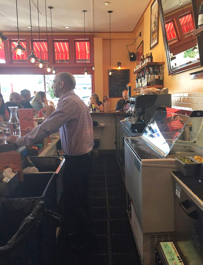 The bustling interior where servers navigate the tight quarters with the grace of Parisian traffic controllers during rush hour.