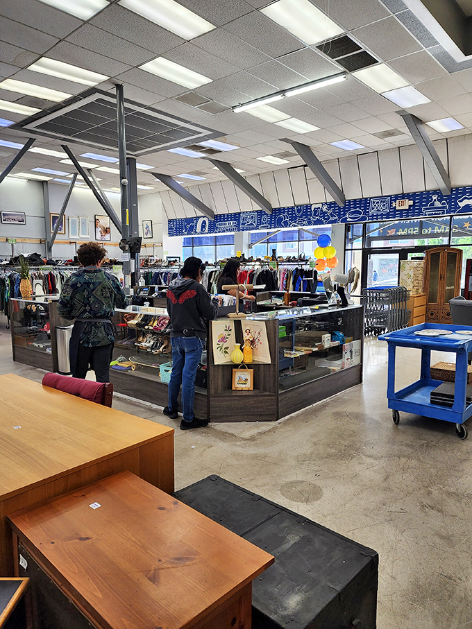 Shoppers browse with that distinctive thrift store posture: part treasure hunter, part archaeologist, all optimist.